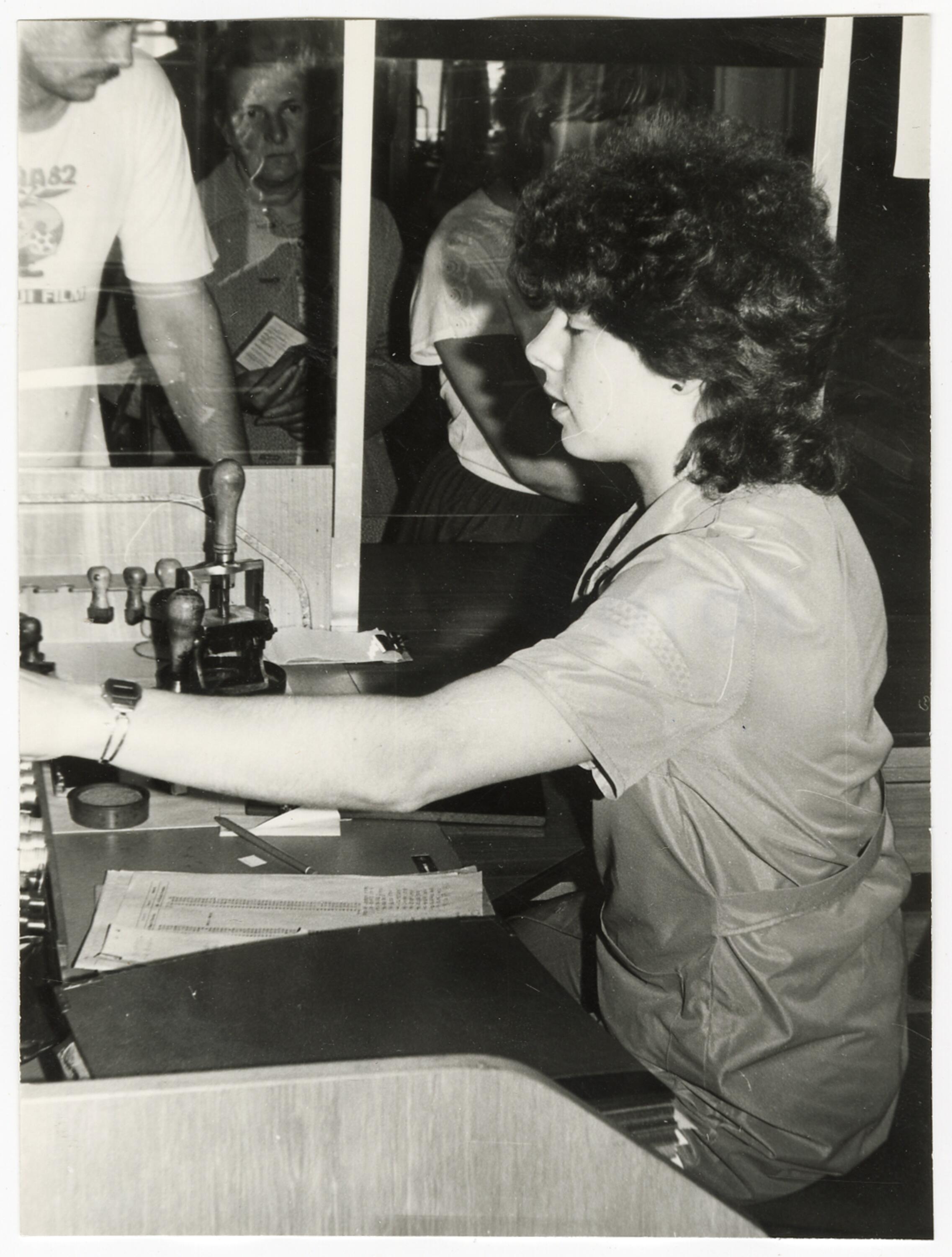 Fotografie, Mitarbeiterin der Deutschen Post der DDR im Postschalter ...